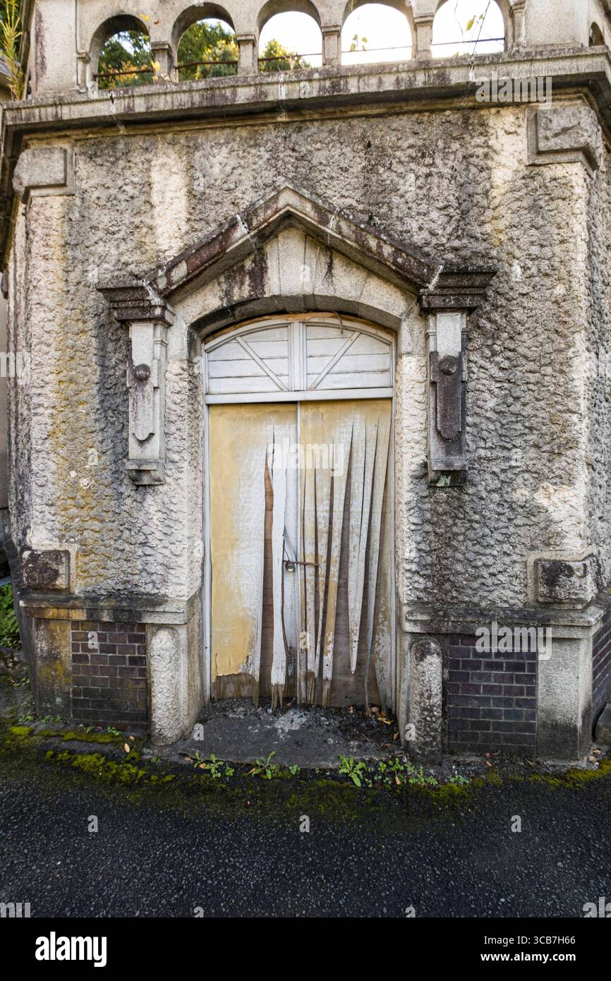 View of a deteriorated building door with peeling wood paneling ...