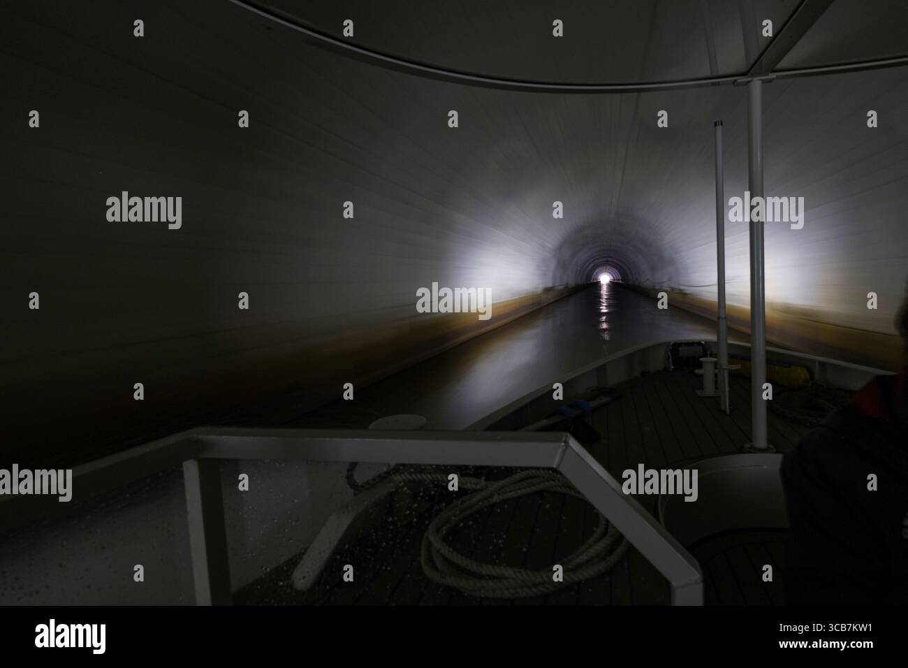 View from a Lake Biwa canal boat navigating inside a dimly lit tunnel ...