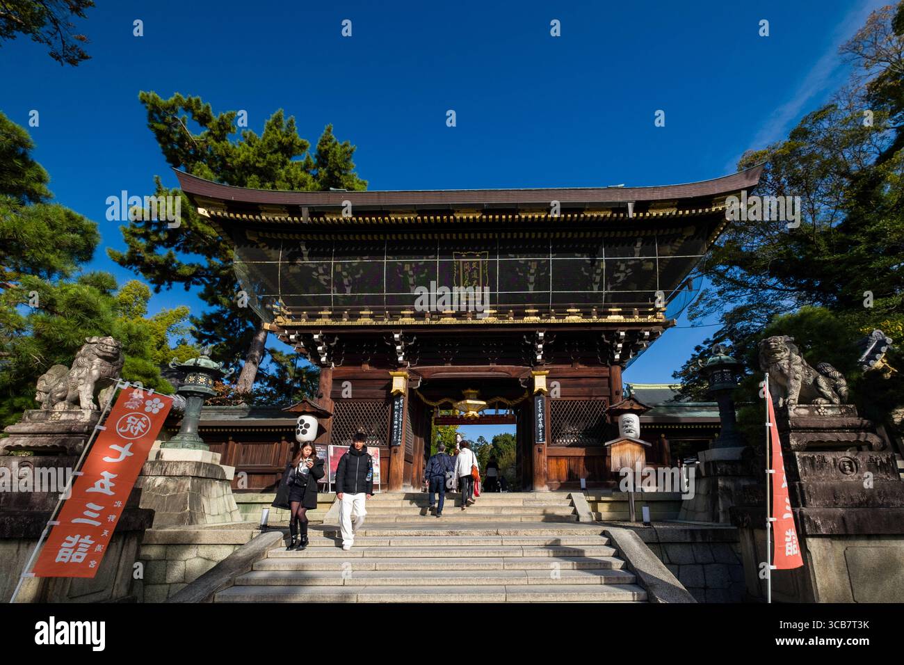 Visitors pass through Kitano Temmangu Romon surrounded by beautiful ...