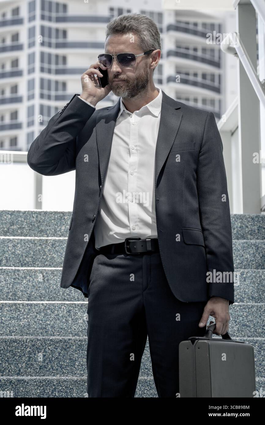 Business man call on the phone outdoors. Confident man making a call ...