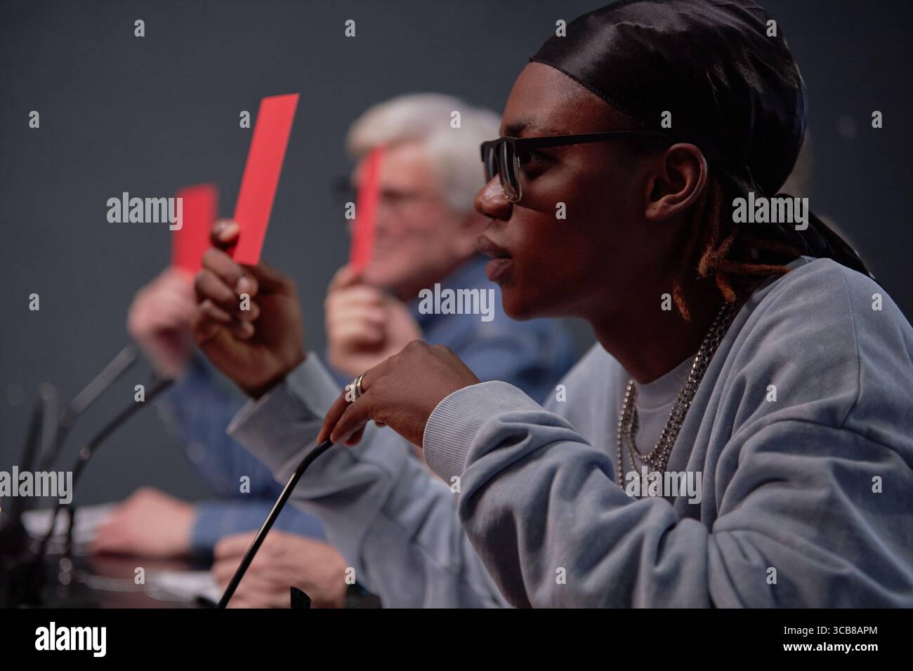 Young Black Man Judging Talent Competition While Holding Red Card in ...