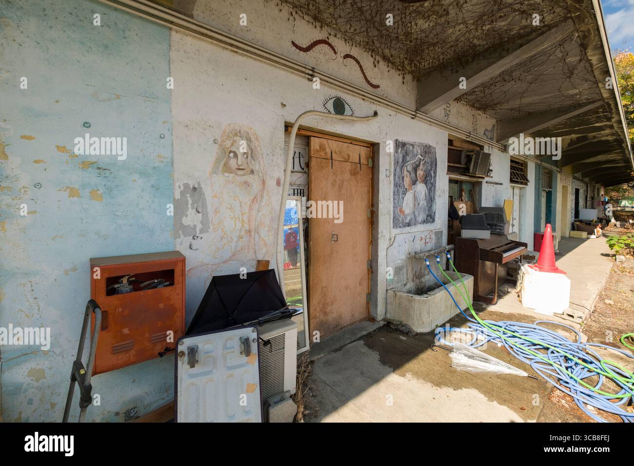 Structure featuring artwork on walls, exposed pipes, a piano, and other ...