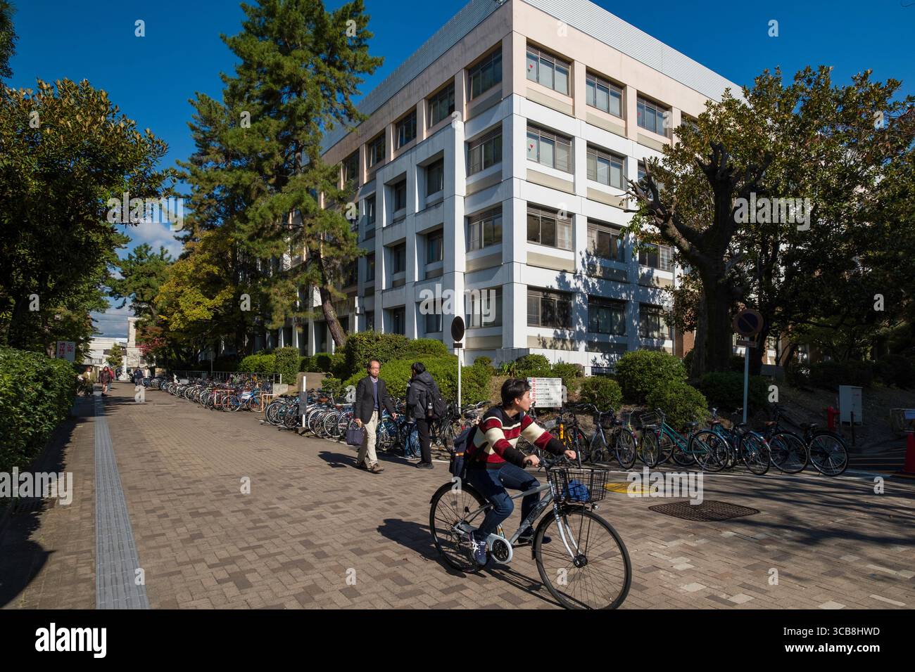 Kyoto University campus walkway featuring bikes, pedestrians, lush ...