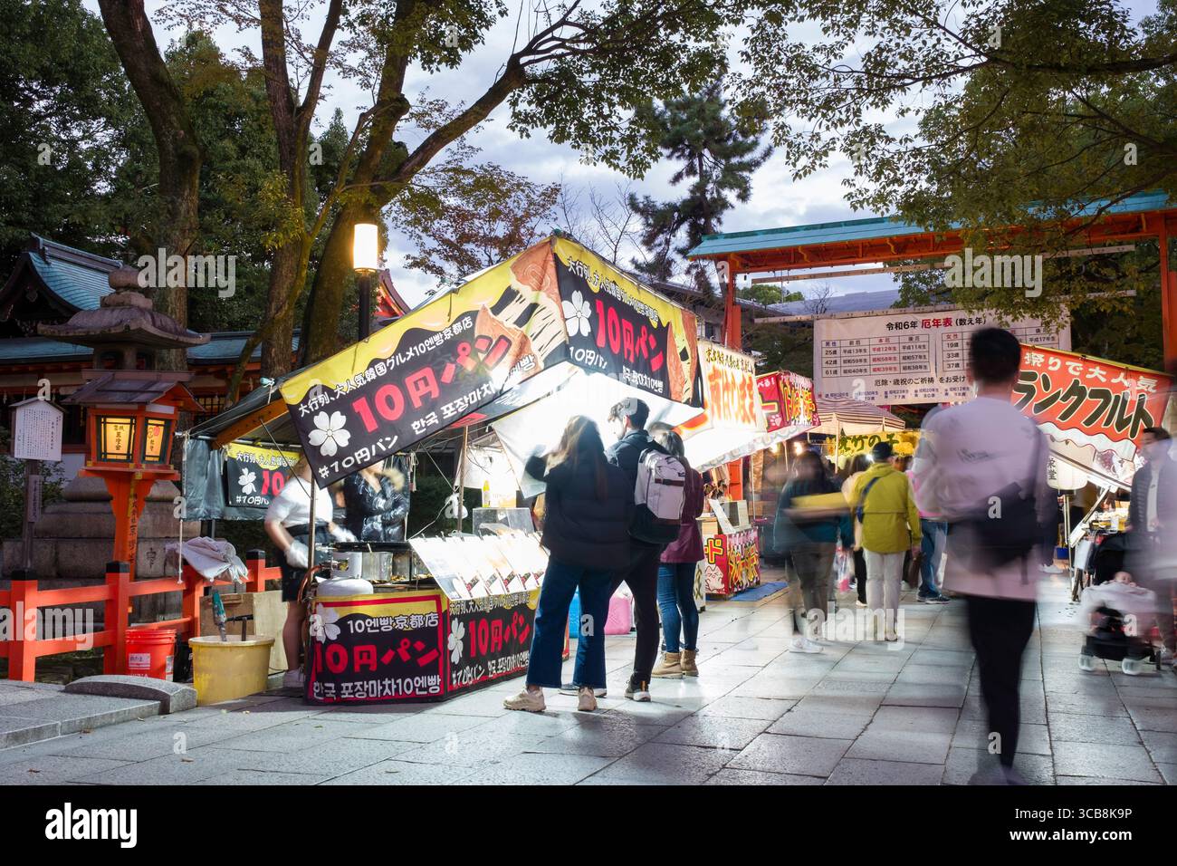 A bustling traditional Japanese market scene with food stalls and ...