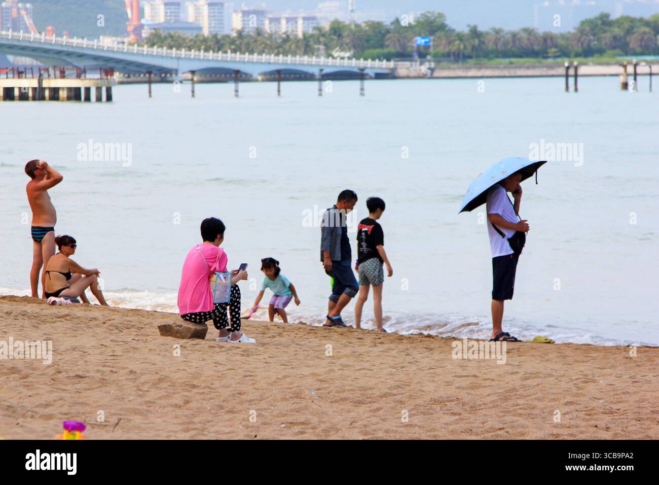 Tourists play at the seaside in Sanya City, southernmost China's Hainan ...