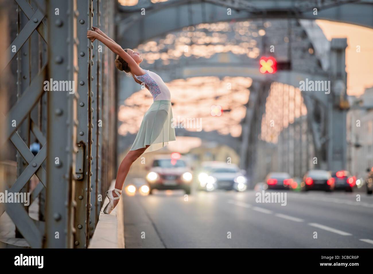 ballerina performing elegant ballet pose on a bridge at sunset Stock ...