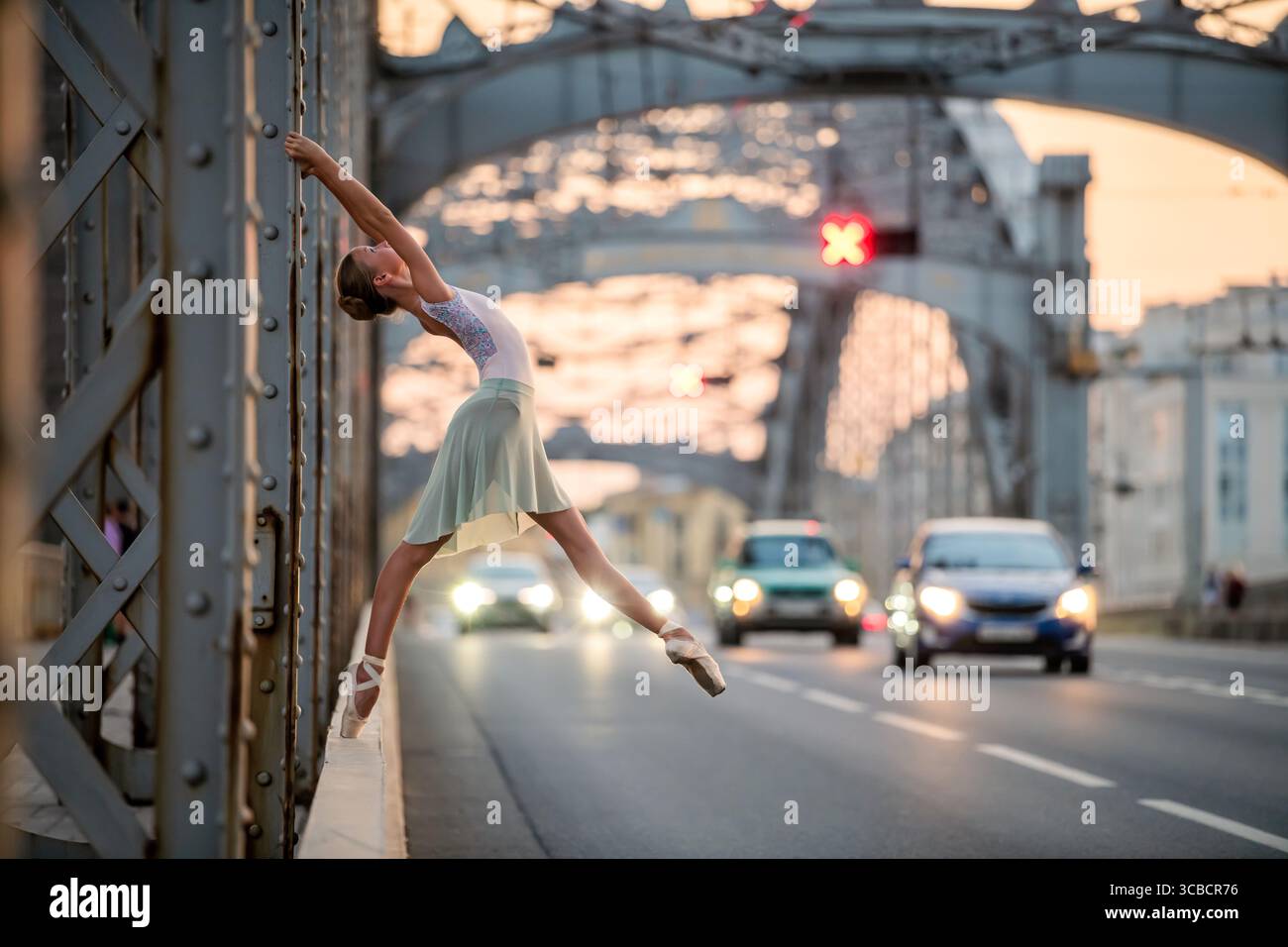 ballerina performing elegant ballet pose on a bridge at sunset Stock ...