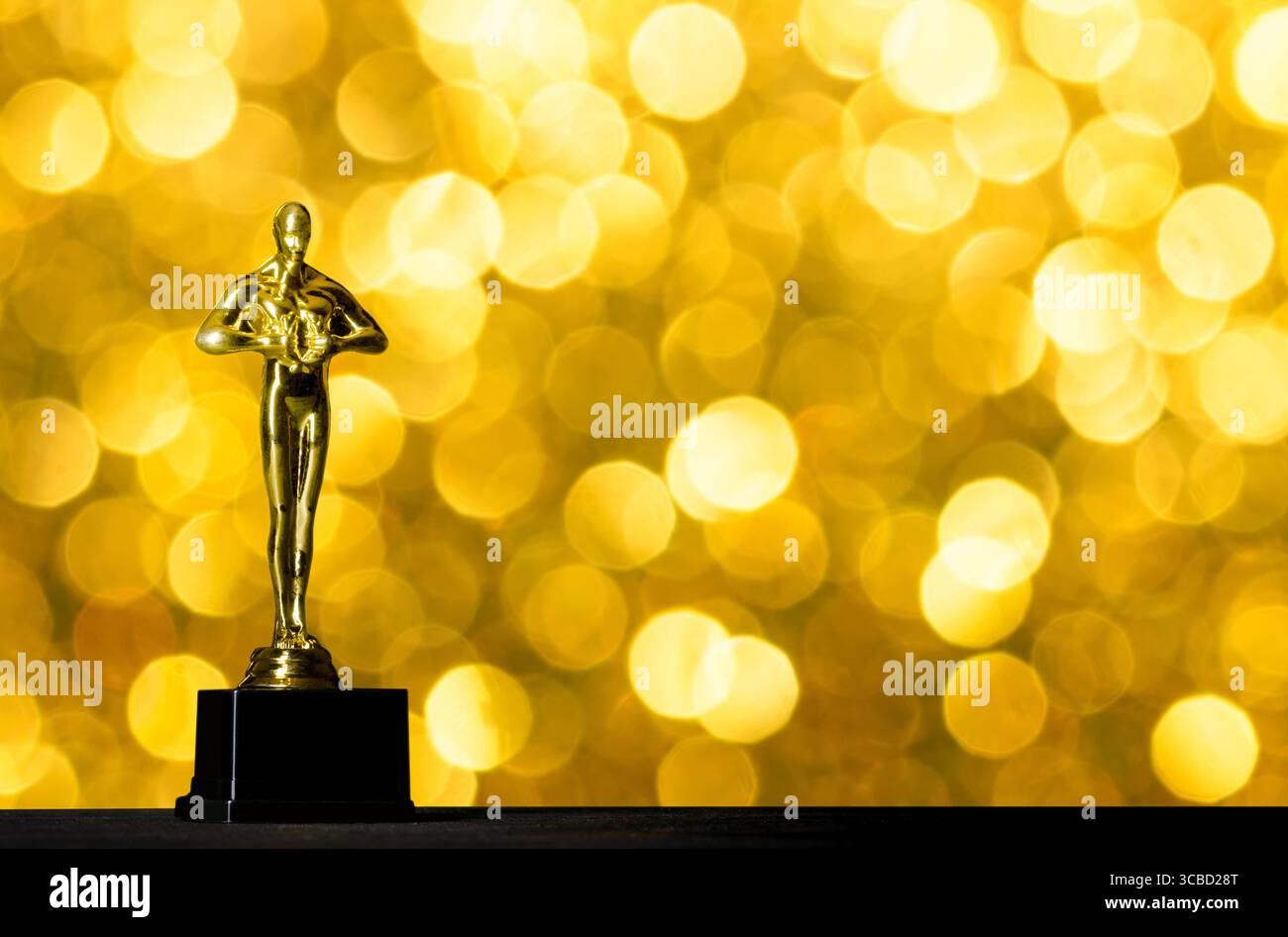 Hollywood Golden Oscar Academy award statue against yellow gold lights ...