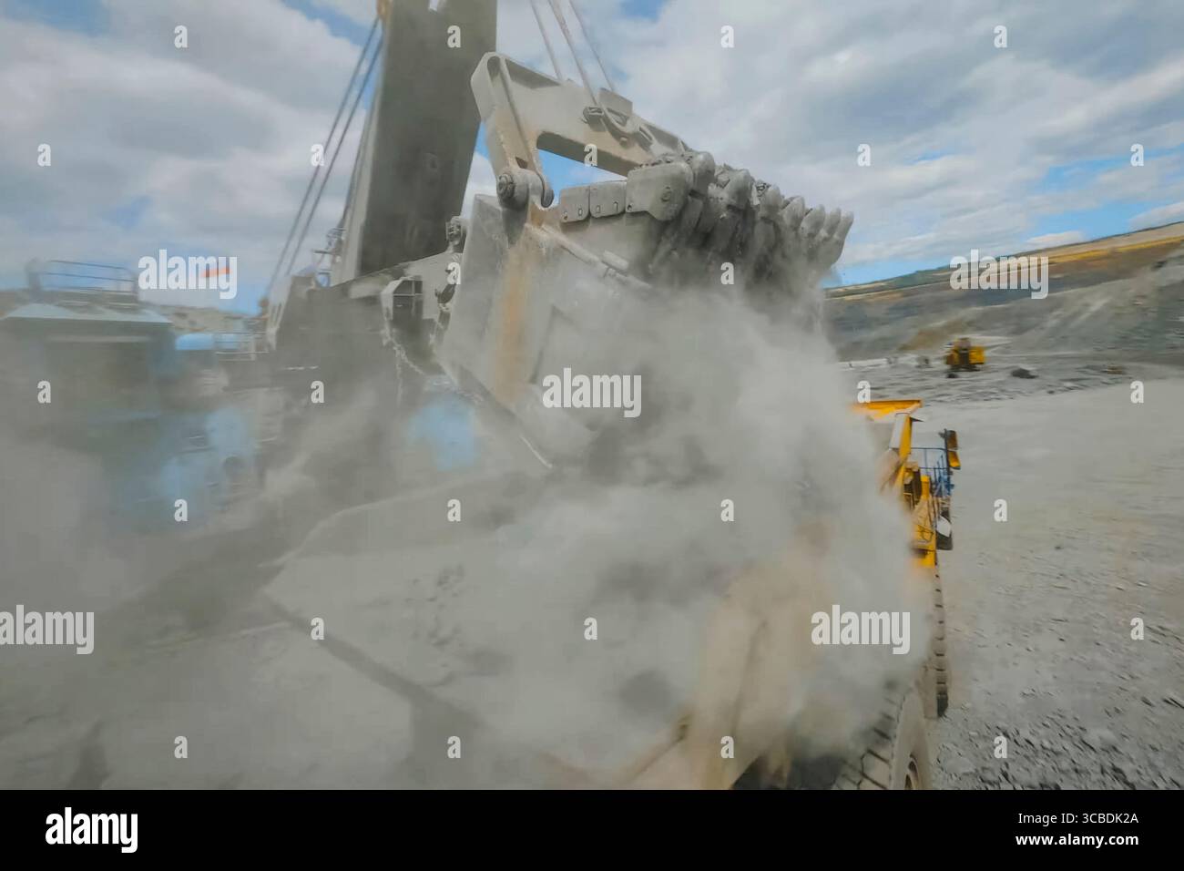 The excavator loads crushed stone into the body Stock Photo - Alamy
