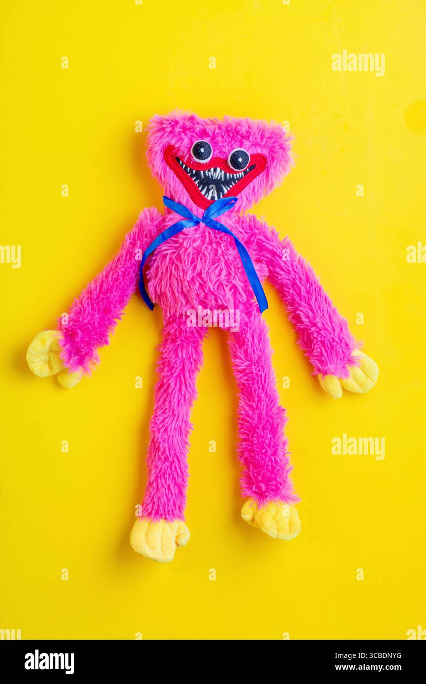 Pink plush monster toy on a bright yellow background Stock Photo - Alamy