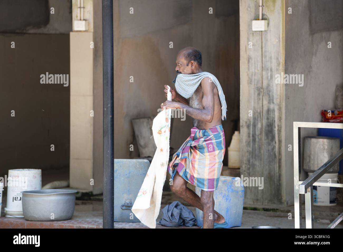 Dhobi Ghat, open air laundry in Kochi, India, man washing pile of dirty ...