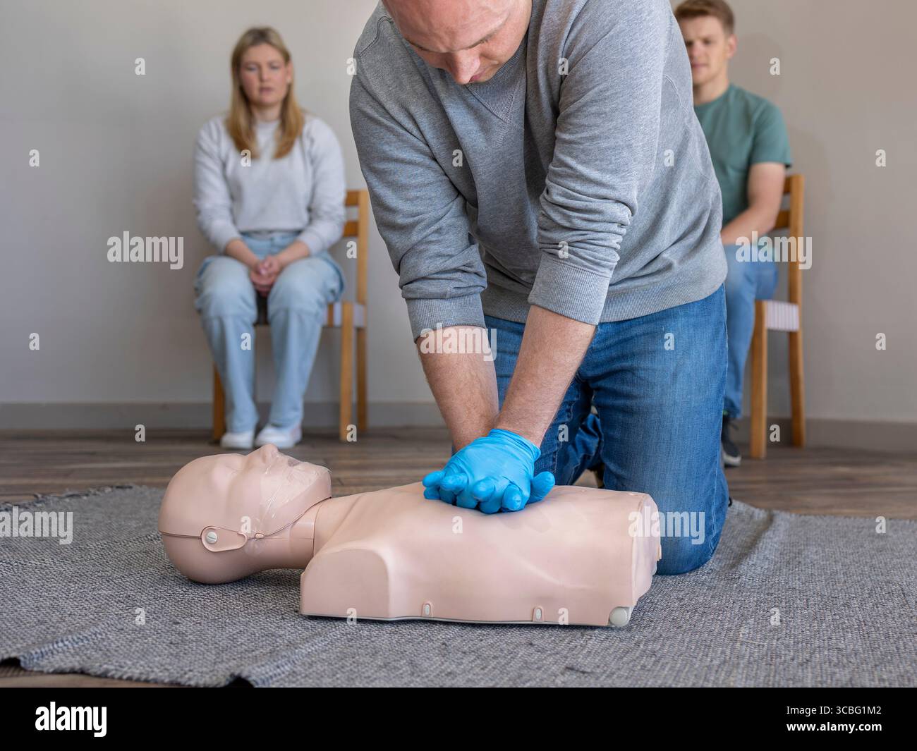 Male student practicing proper chest compression technique on a Basic Life Support (BLS) CPR ...