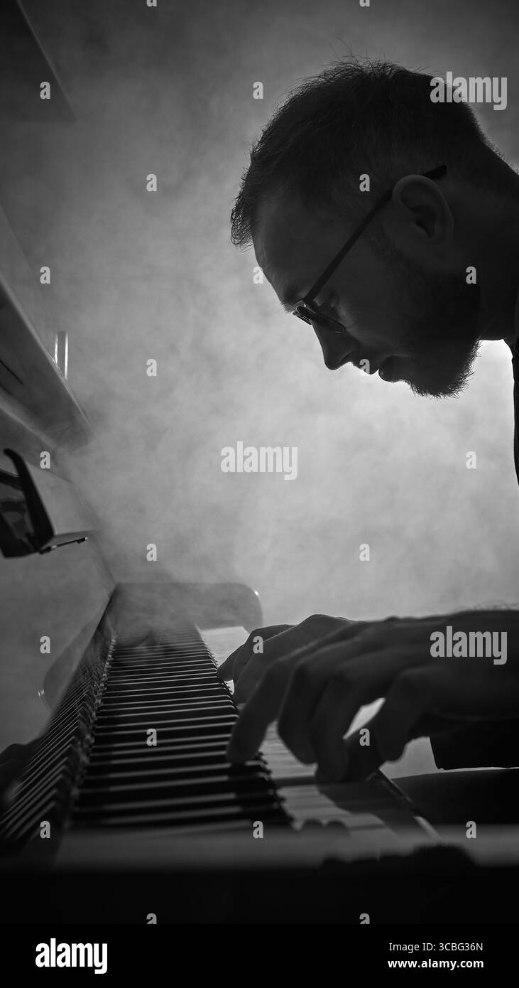 Pianist in side view playing piano with intense focus and dramatic ...
