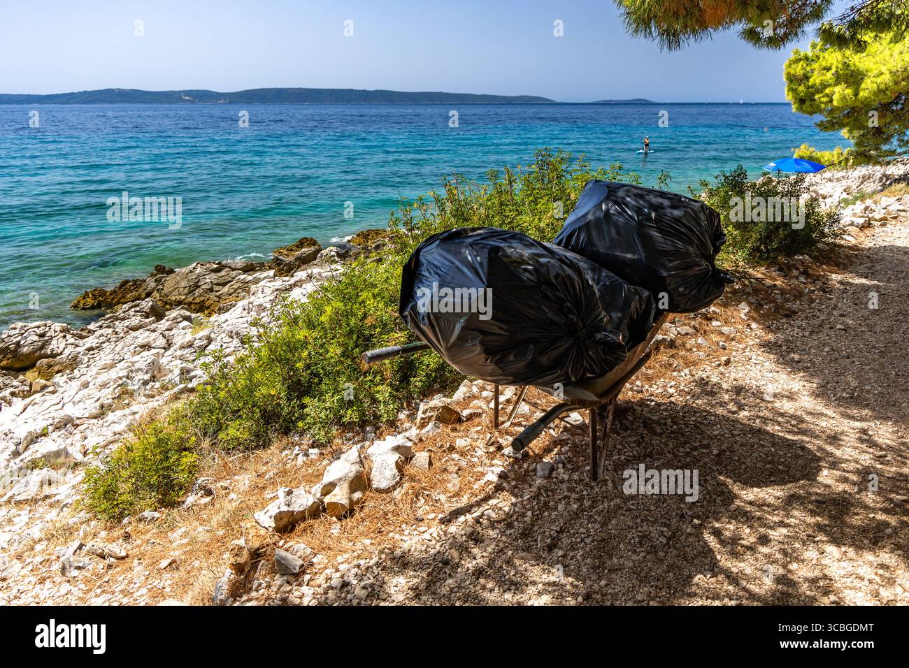 Black garbage bags collected on the beach, beach waste removed in a ...