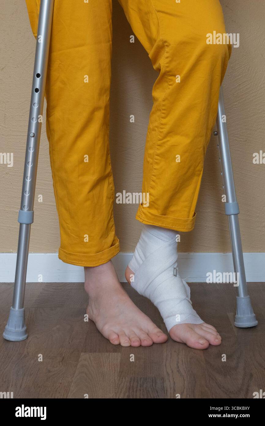 Person with sprained foot using crutches, healing process Stock Photo ...