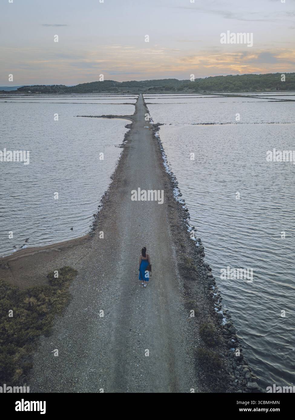 Aerial view of a solitary figure trekking along a narrow path through ...