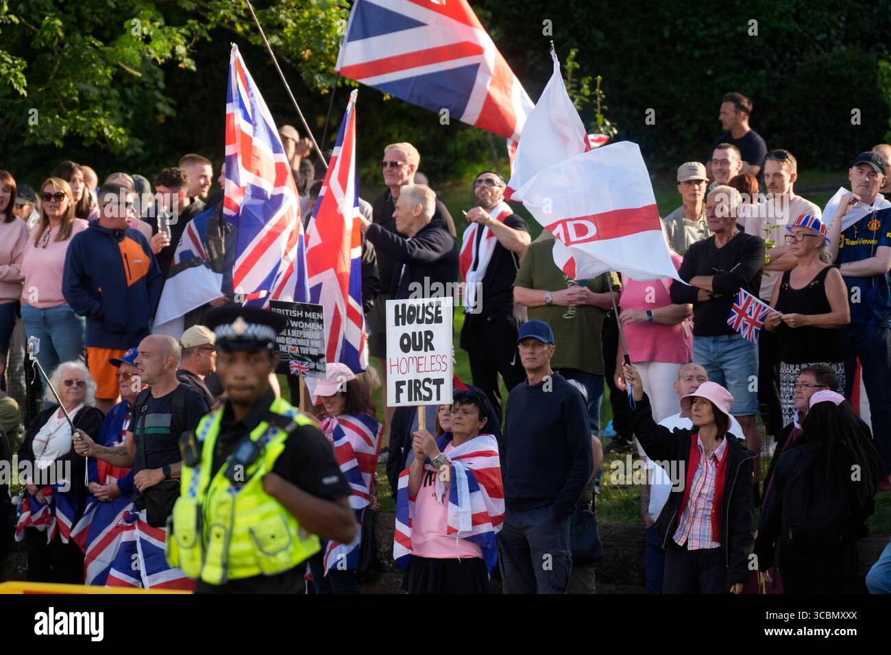 Counter-protesters holding signs and England and Union Jack flags at ...