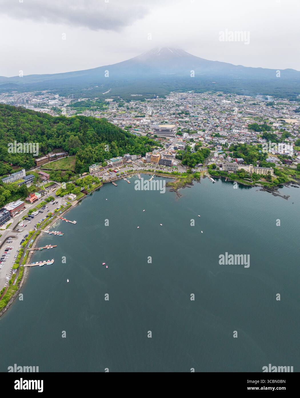 Aerial view of Mount Fuji's majestic peak rises over the town ...