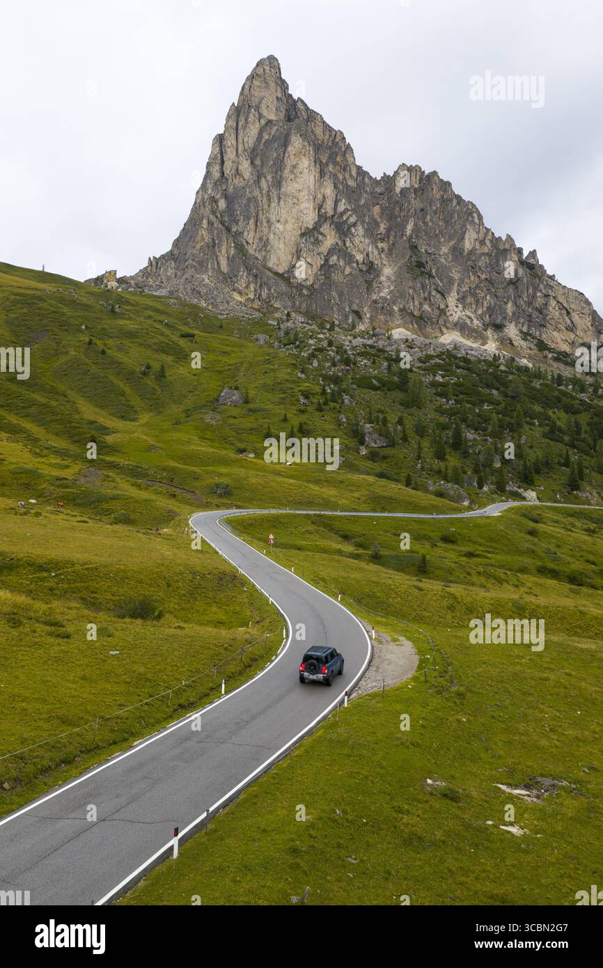Aerial view of a lone car makes its way along a winding road, framed by ...