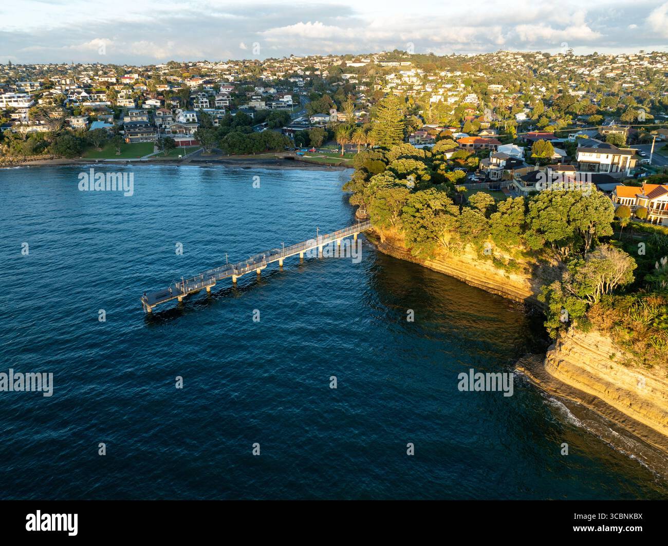 Aerial view of a pier stretching out into the deep blue waters of the ...