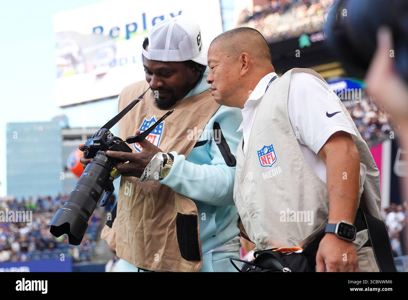 Former NFL player Marshawn Lynch, left, shows his photos to Seattle ...