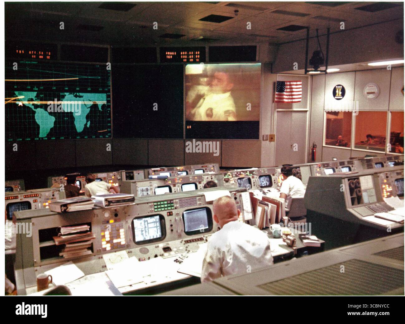 Gene Kranz (foreground, back to camera), an Apollo 13 Flight Director ...