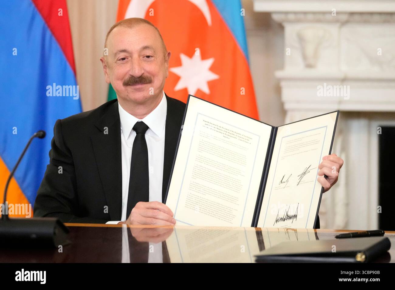 Azerbaijan President Ilham Aliyev holds a signed trilateral agreement ...