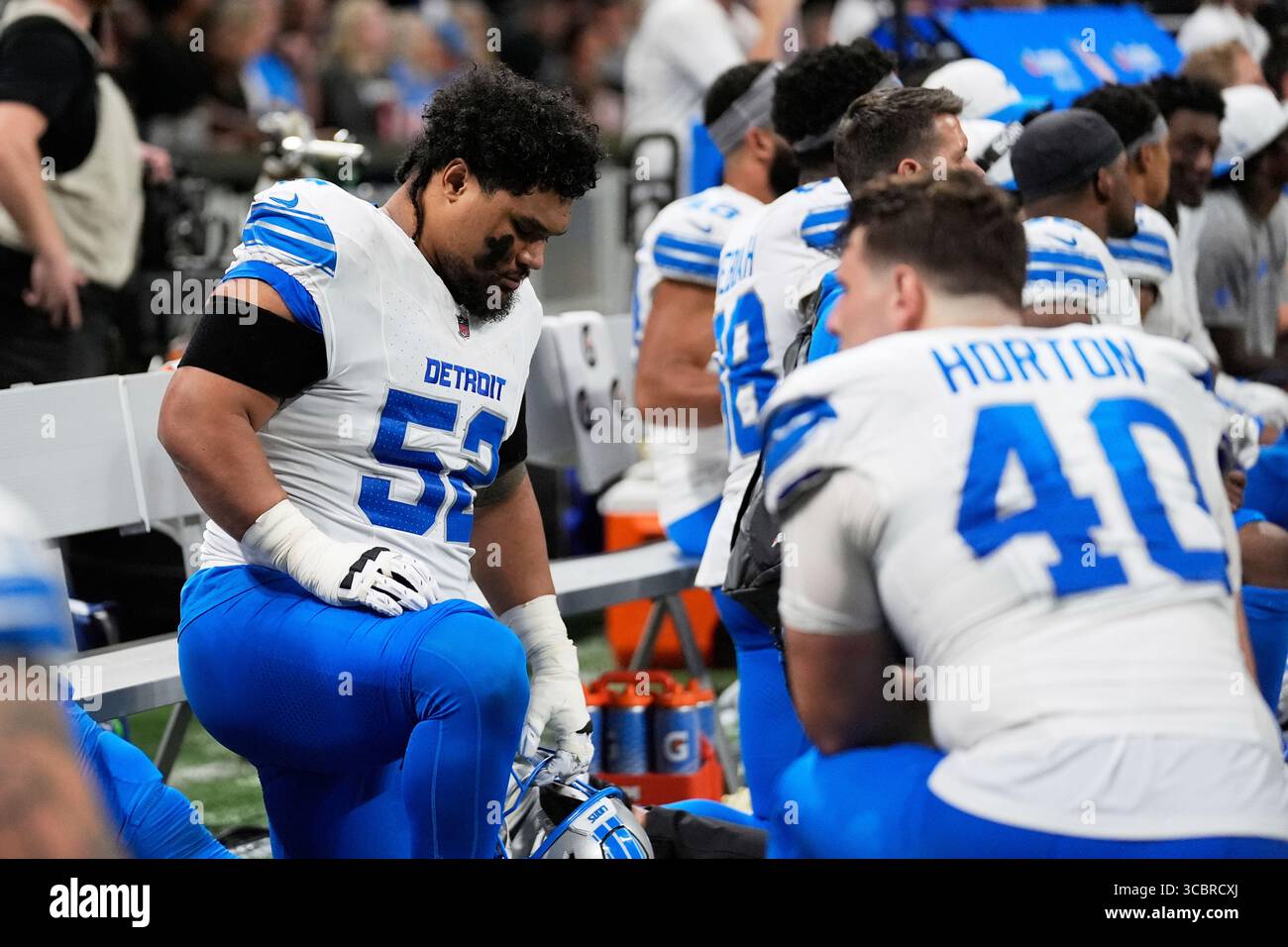 Detroit Lions players kneel on the bench while safety Morice Norris is ...