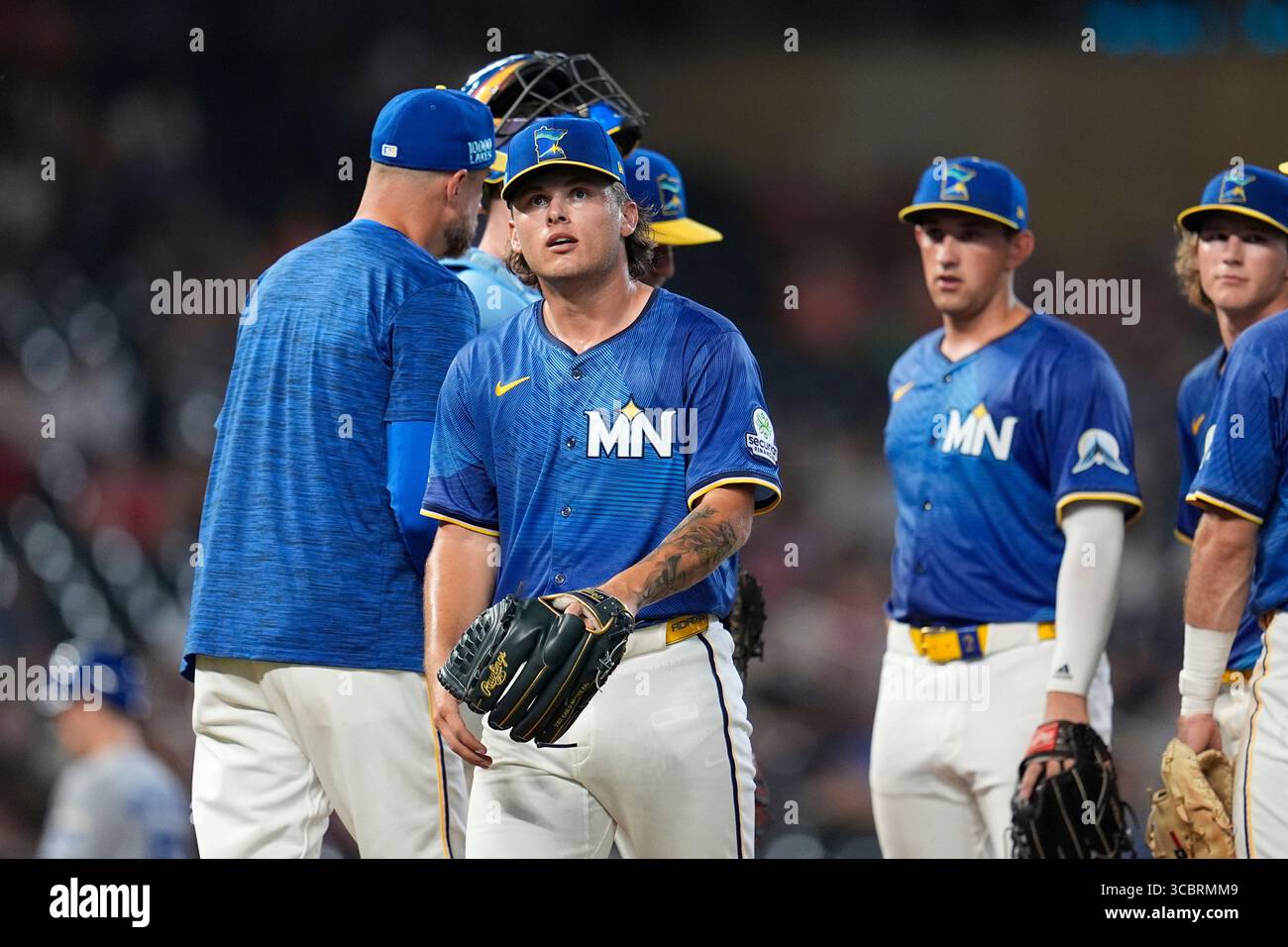 Minnesota Twins reliever Travis Adams, front left, walks back to the ...