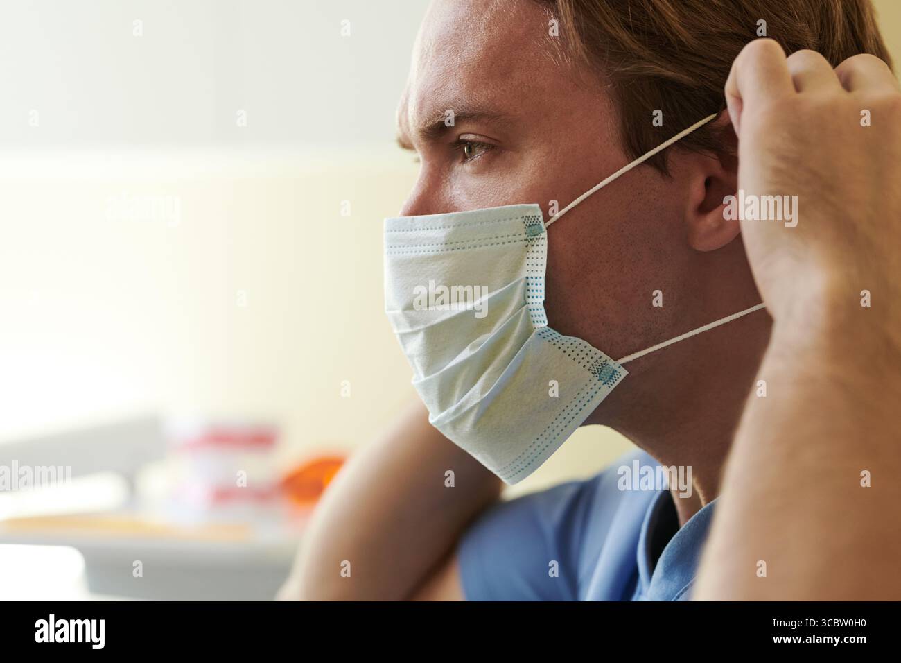 Doctor adjusting mask loops hi-res stock photography and images - Alamy