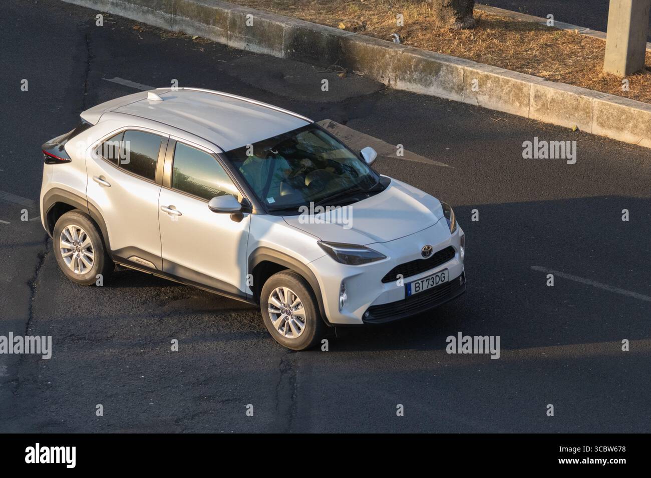 Modern white crossover car driving on asphalt road at sunset Stock ...