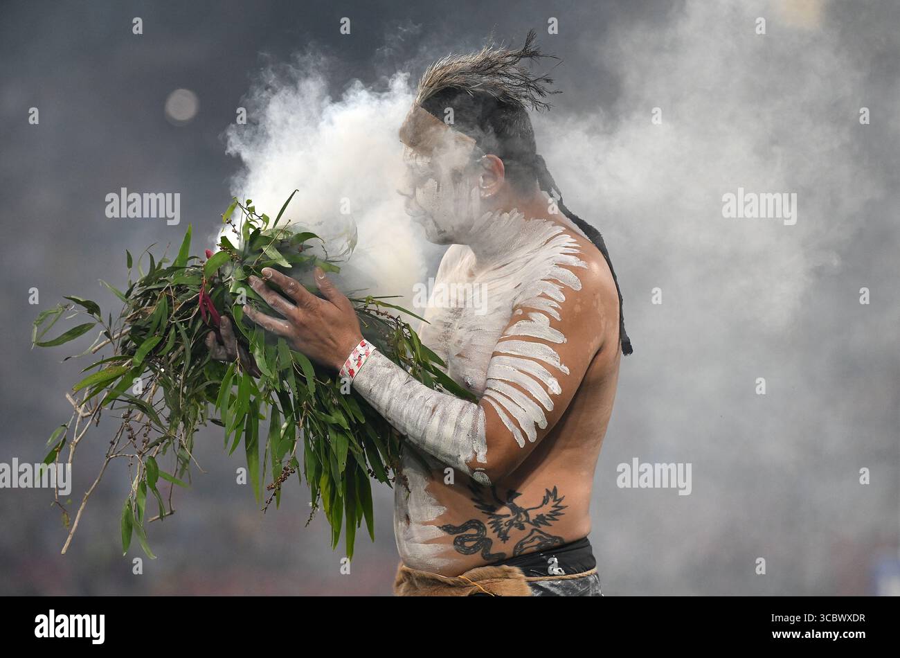 A smoking ceremony prior to the NRL Round 23 match between the Dolphins ...