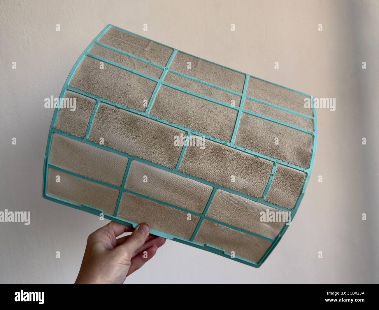 Extremely dusty and clogged AC filter held in hand on white background ...