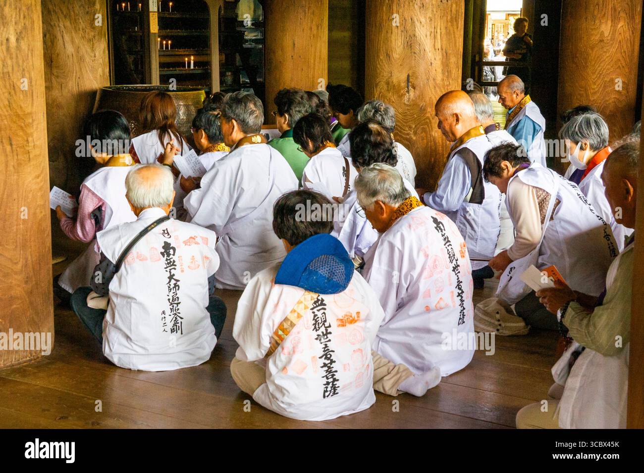 Japanese senior pilgrims sitting and chanting in front of the altar in ...