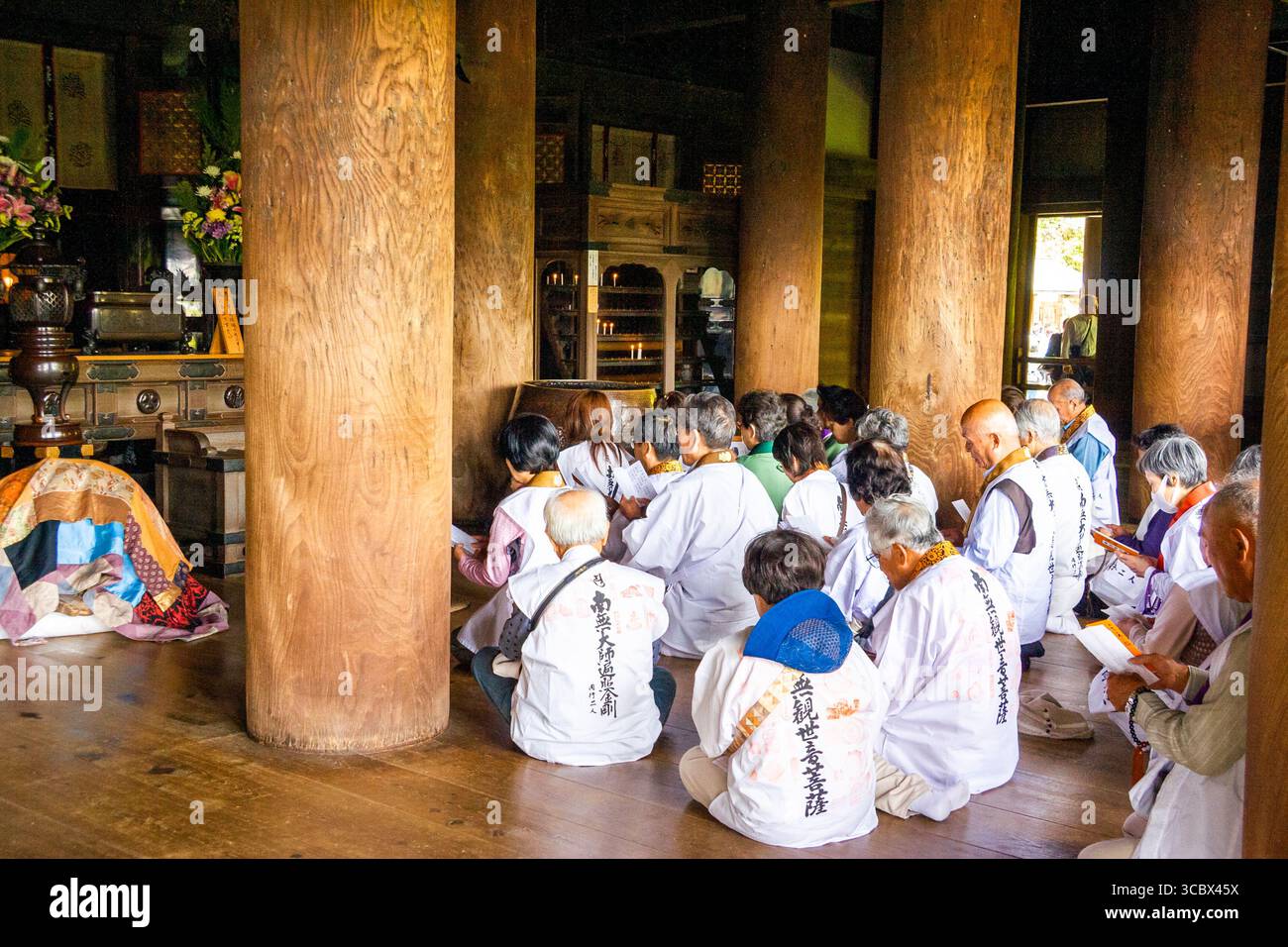 Japanese senior pilgrims sitting and chanting in front of the altar in ...