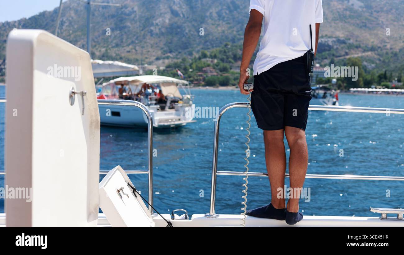 Man sailing on yacht on sea. Captain is mooring to a pier in a yacht ...