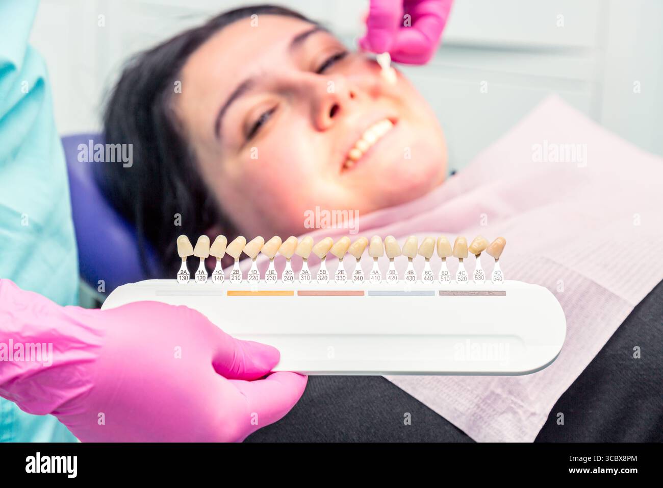Dentist holding shade guide or palette for teeth whitening and choosing ...