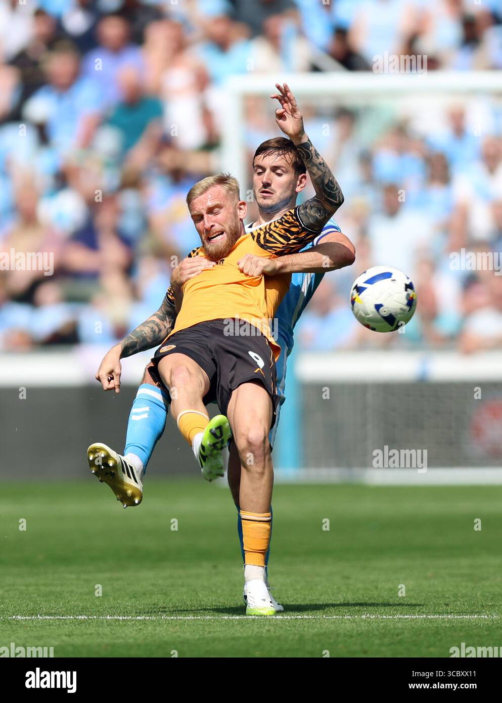Hull City's Oliver McBurnie (left) and Coventry City's Liam Kitching ...