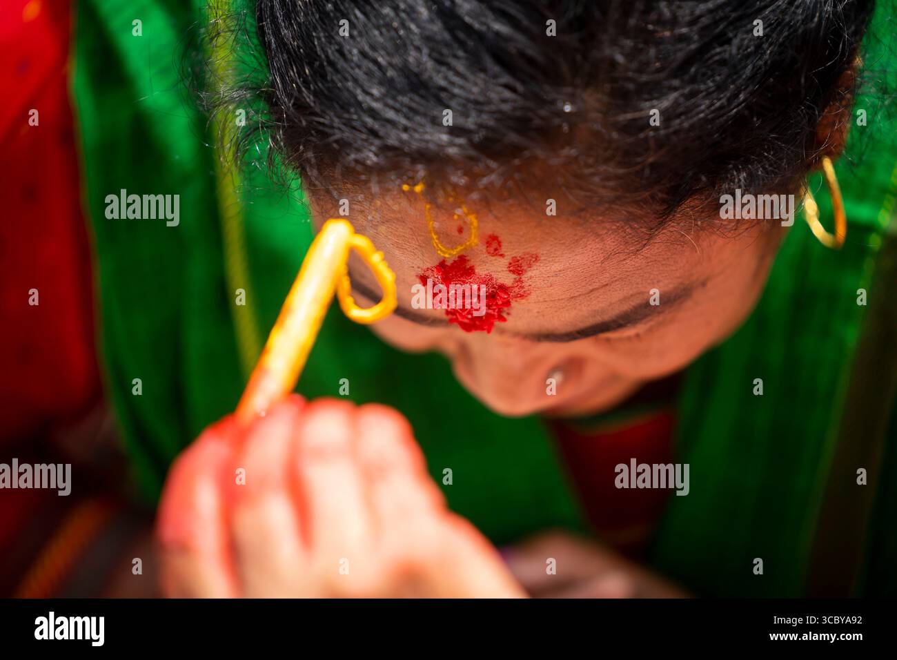 Lalitpur, Nepal. 9th Aug, 2025. A devotee receives tika on her forehead ...