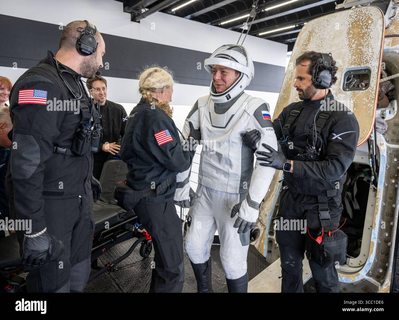 Roscosmos cosmonaut Kirill Peskov is helped out of the SpaceX Dragon ...