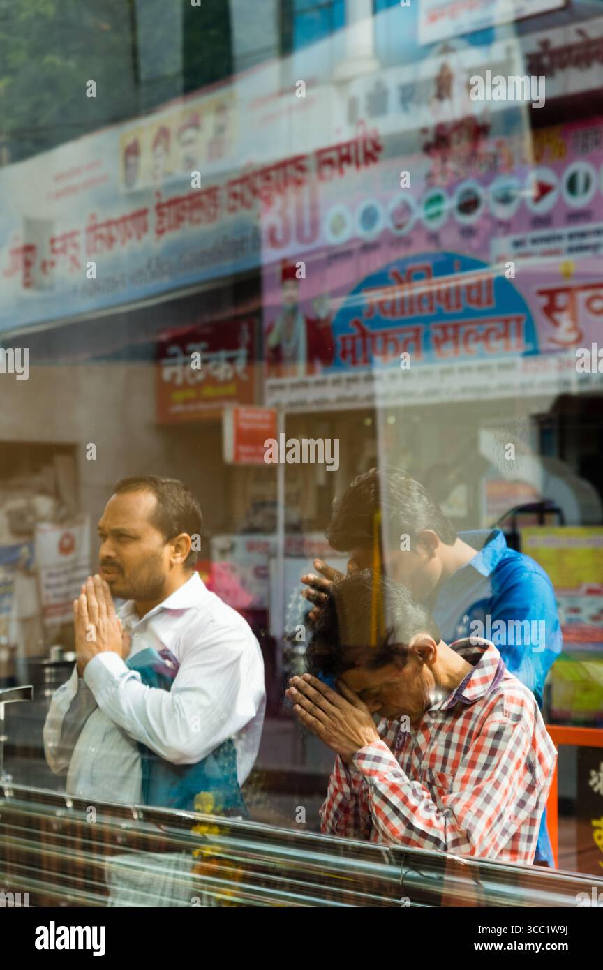 Hindu devotees praying through a glass window, Shreemant Dagdusheth ...