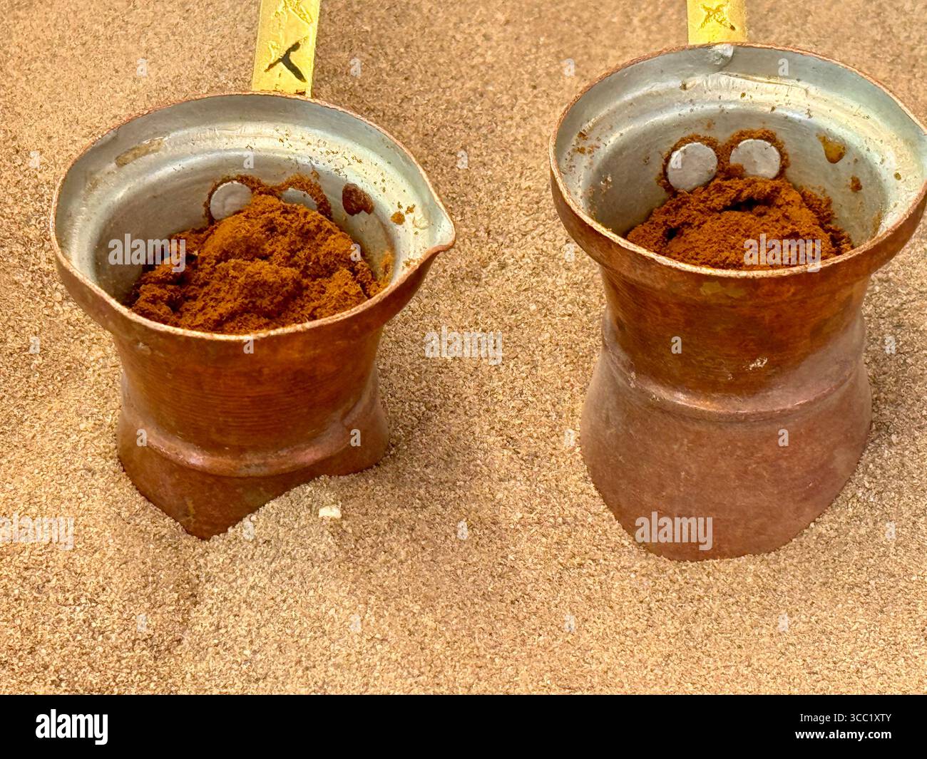 Greek coffee brewed traditionally over hot sand using a copper pot, a ...