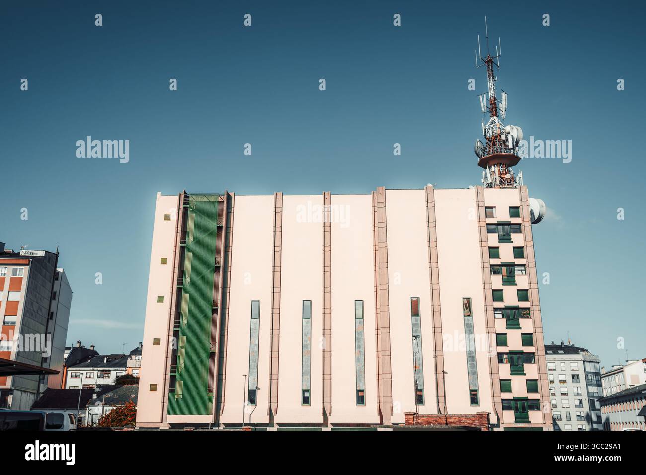 Modern beige building with narrow vertical windows, green facade ...