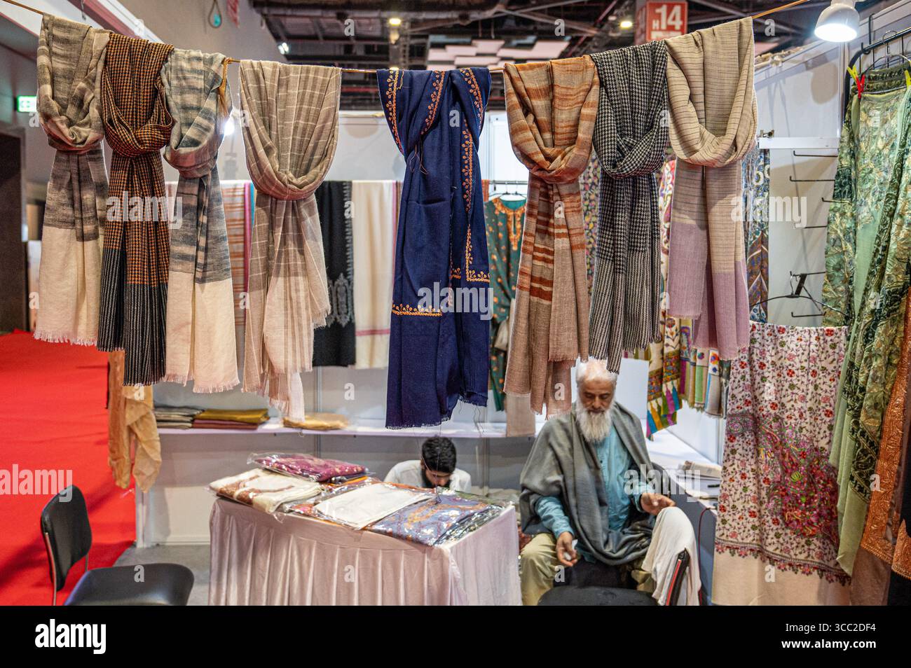 A Jammu and Kashmir stall showcasing pashmina shawls hanging on a rope ...