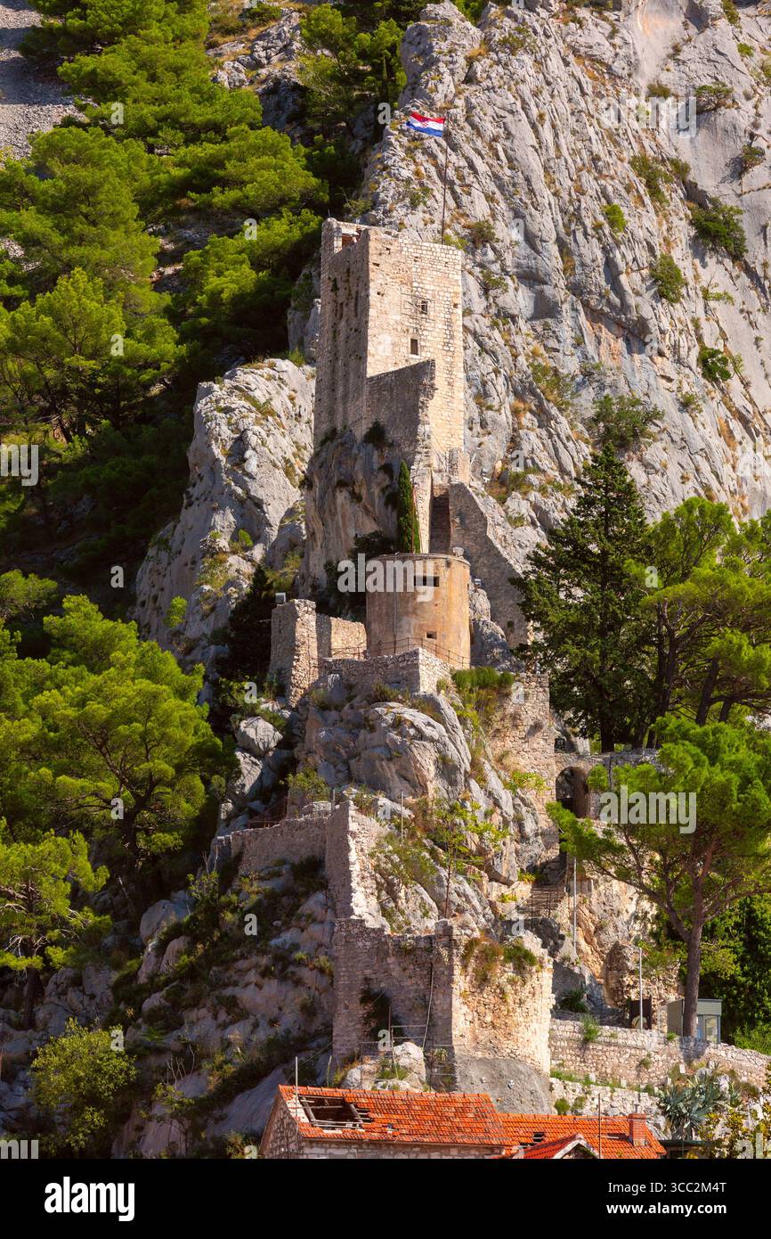 Stone walls and tower of Mirabella Fortress on a rocky hillside in Omis ...