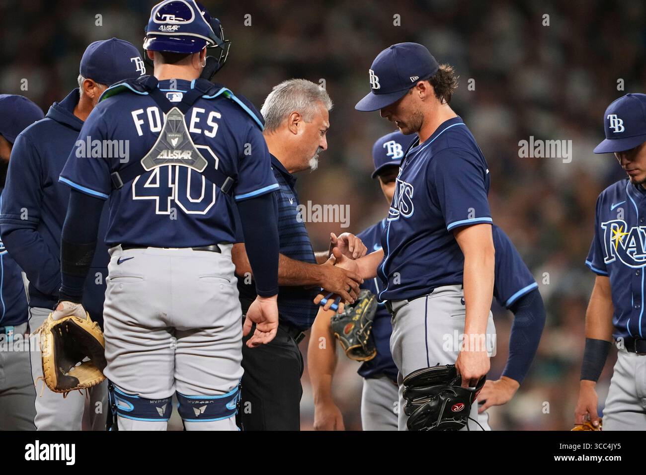 Tampa Bay Rays relief pitcher Mason Englert is looked at by a trainer ...