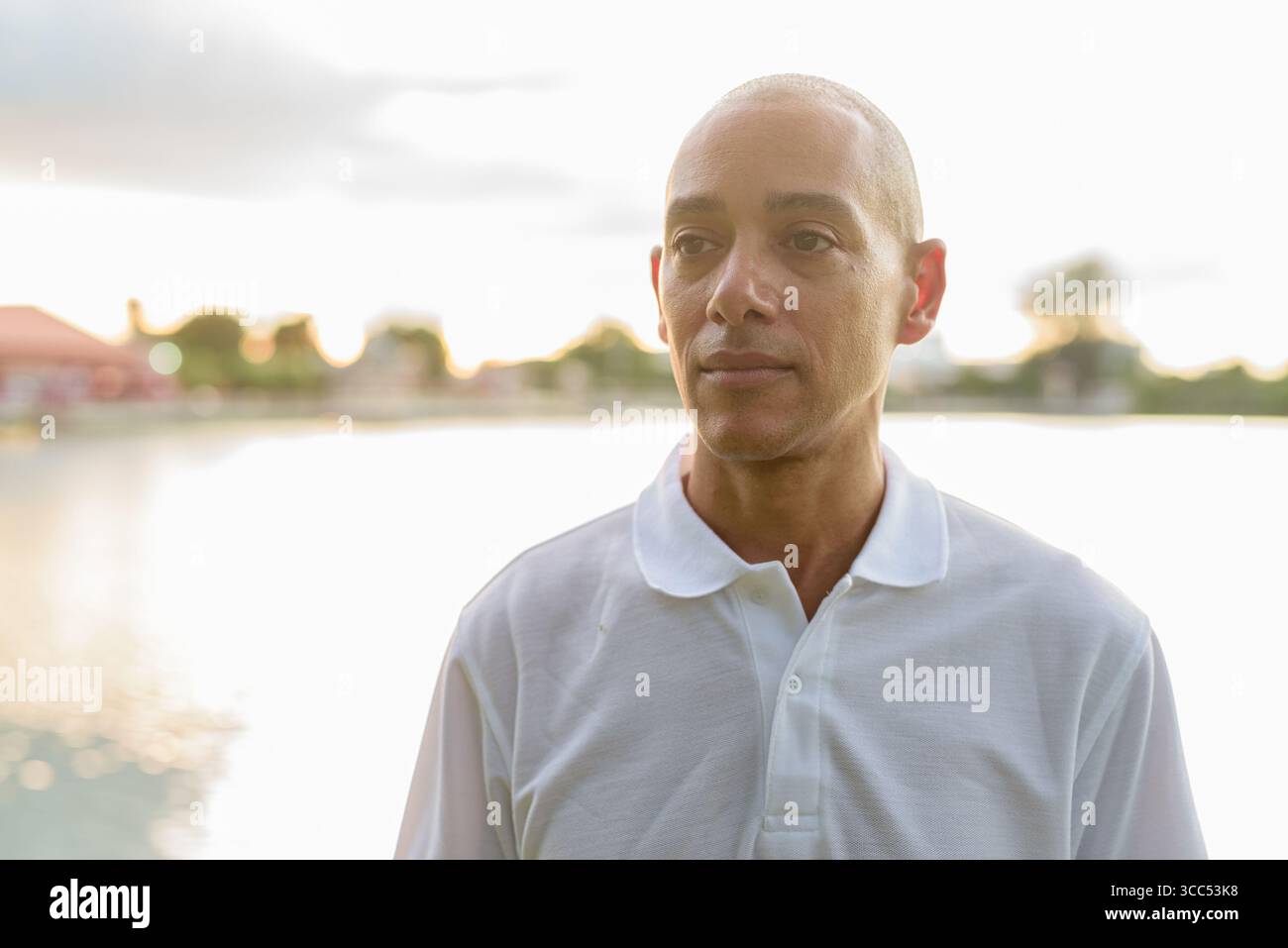 Summer portrait of bald handsome Italian man face next to park lake ...