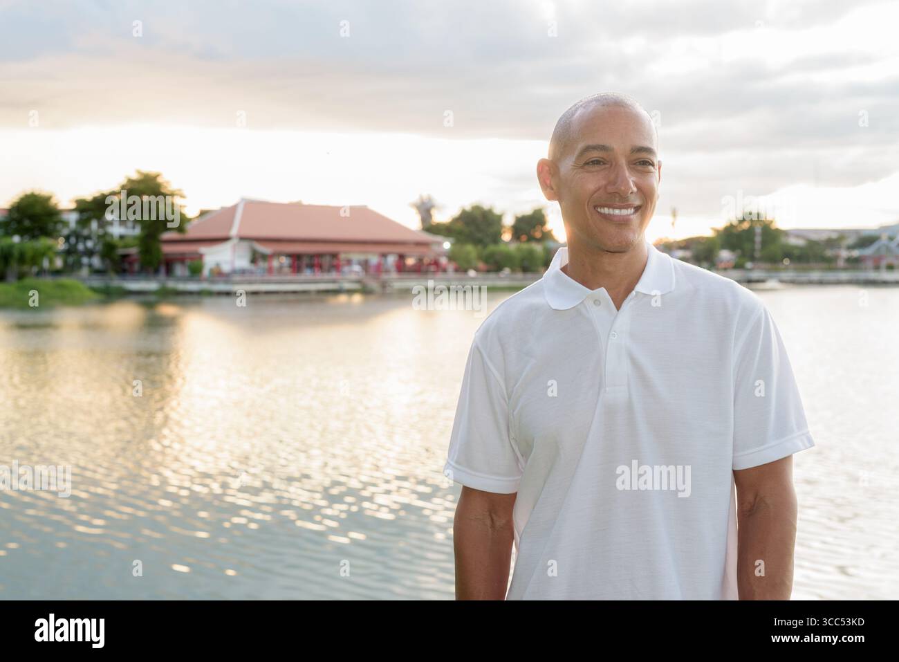 Summer portrait of bald handsome Italian man next to park lake during ...