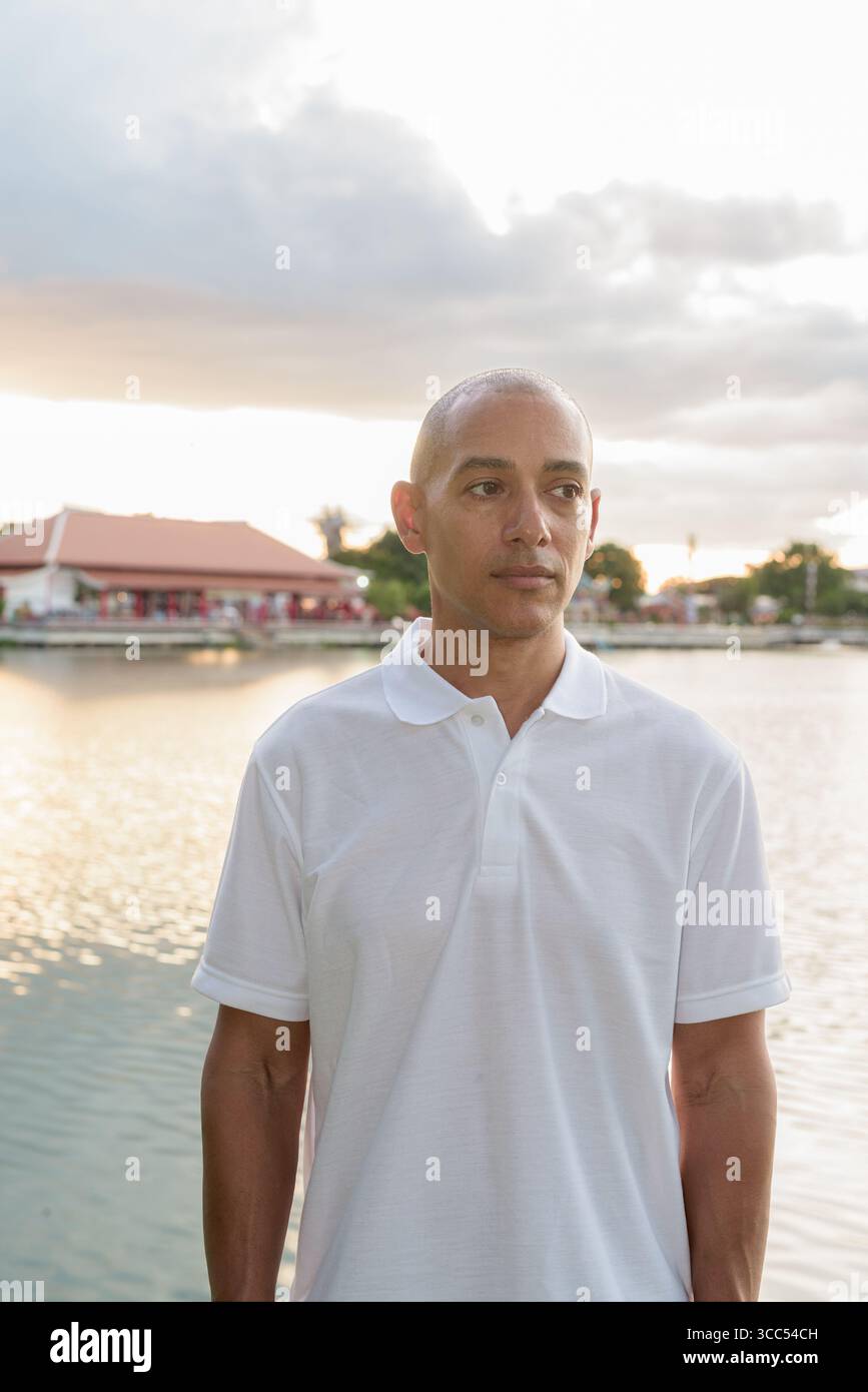 Summer portrait of bald handsome Italian man next to park lake during ...