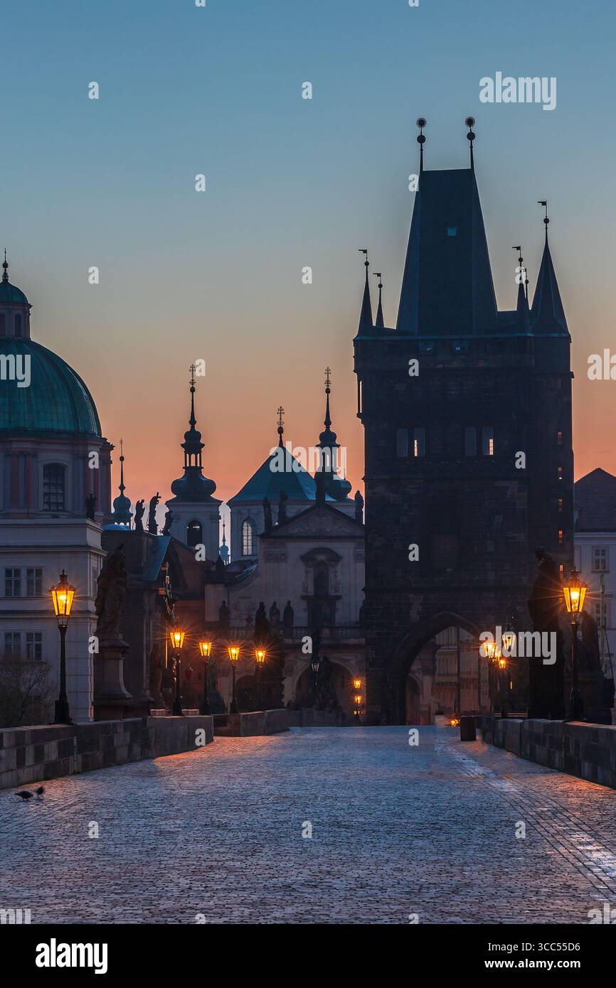 Charles Bridge in Prague, Czech Republic, at dawn with glowing street ...